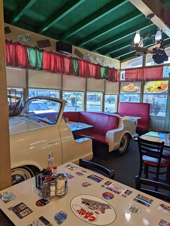Not just a booth—a time capsule with red vinyl seating and checkered curtains. The vintage car seating area proves Crazy Otto's knows eating is as much about atmosphere as appetite.