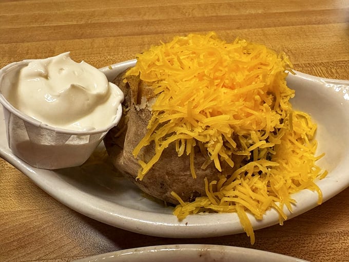 A loaded baked potato that's dressed for success – cheese melting like a sunset over fluffy potato mountains.