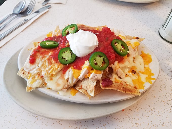 Nachos that understand the importance of proper cheese-to-topping ratio—a architectural marvel topped with jalapeños for those who like their memories spicy.