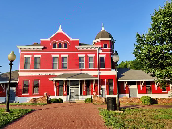 The vibrant red Old Depot Museum pops against blue Alabama skies, its Victorian architecture a reminder of Selma's railroad heyday.