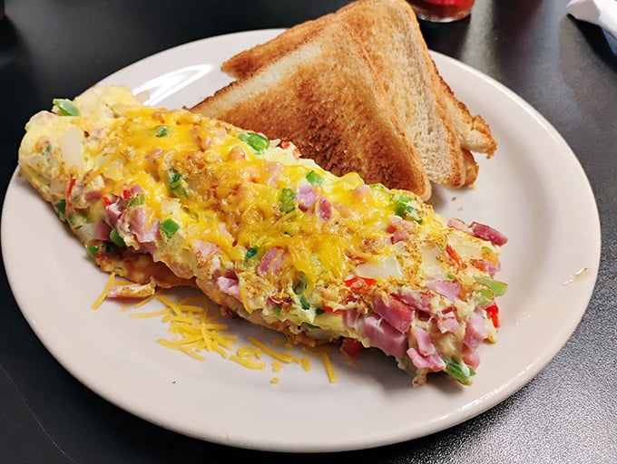 This isn't just an omelet—it's a colorful canvas of diced ham, peppers, and cheese that makes breakfast feel like the most important meal of the day.