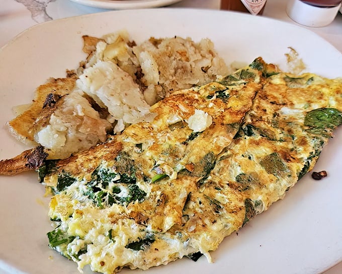 An omelet that's had a proper education in vegetable integration. Those home fries look like they've been studying crispiness for years.