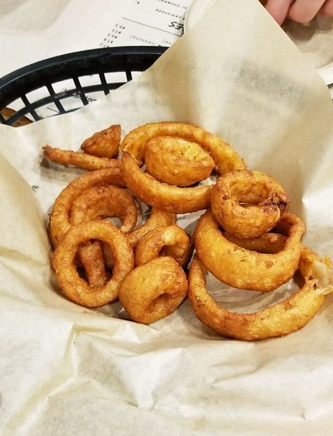 Onion rings with architectural integrity—golden hoops of beer-battered perfection that maintain their structure while surrendering to your bite.