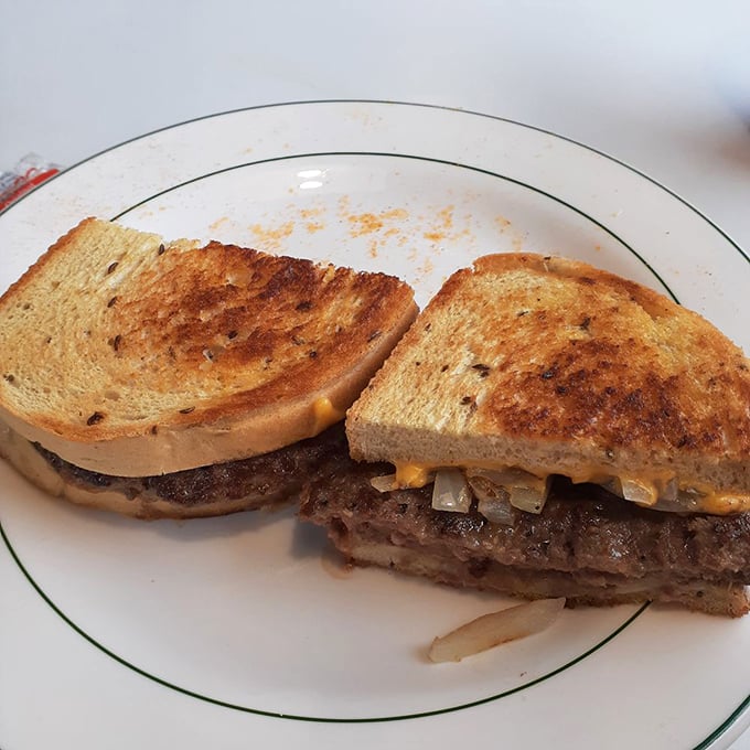 The patty melt—that brilliant marriage of burger and grilled cheese—toasted to perfection with melty cheese and grilled onions peeking out like shy but delicious guests.