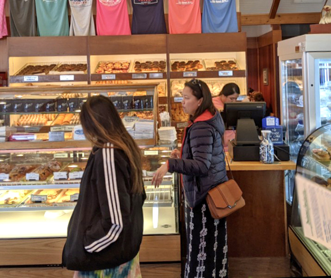 The bakery counter where dreams come true. Watching customers deliberate between donuts is better than any reality TV show.