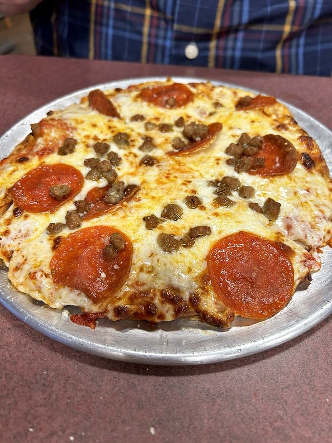 Pizza perfection doesn't need to be complicated. Pepperoni, sausage, cheese – the holy trinity of pizza toppings on full display.