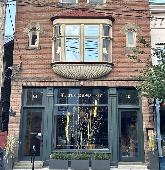 This elegant storefront with its distinctive bay window houses Pigeon Hill Studios, where Victorian architectural flourishes meet modern retail sensibilities.