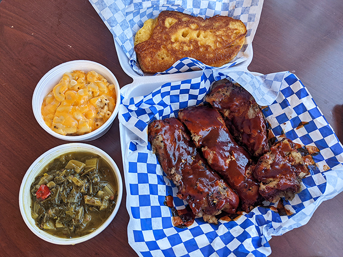 Barbecue ribs glistening with sauce, flanked by mac and cheese and greens—a plate that doesn't just satisfy hunger but soothes the soul.