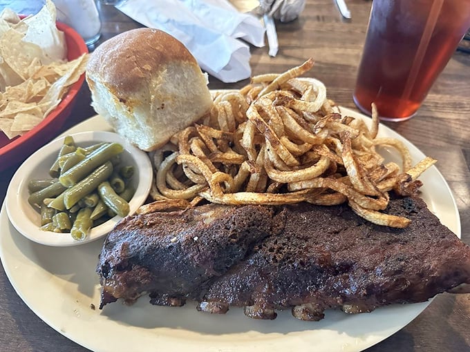 These ribs aren't falling off the bone – they're voluntarily leaping into your mouth, bringing along crispy onion straws and green beans for the ride.