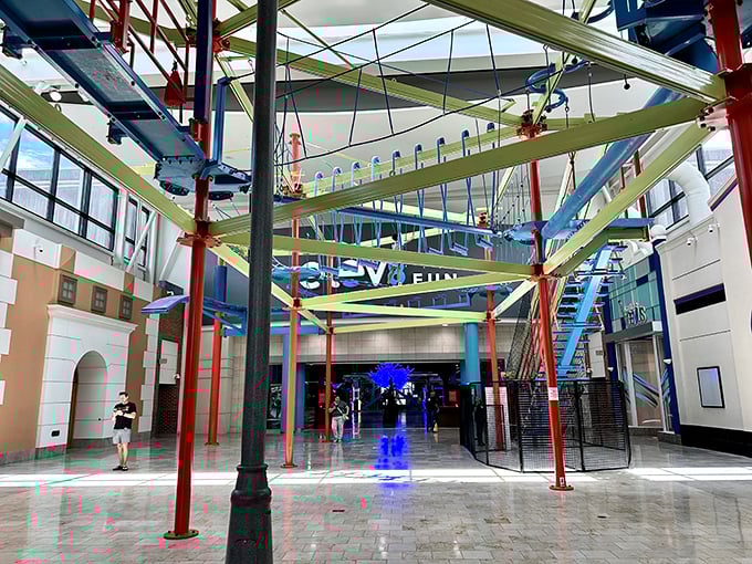 A colorful ropes course stretches skyward like an industrial rainbow, challenging visitors to navigate pathways that test both courage and coordination.