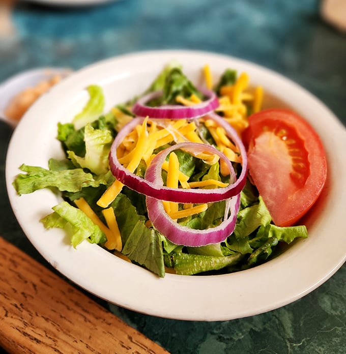 Even the side salad gets special attention – crisp greens, vibrant vegetables, and a simplicity that respects good ingredients rather than drowning them.