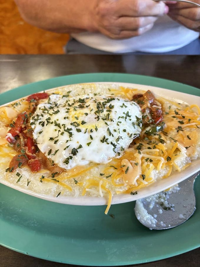 Shrimp and grits get the royal treatment with a crown of melted cheese and fresh herbs—Southern coastal tradition meets mountain hospitality.
