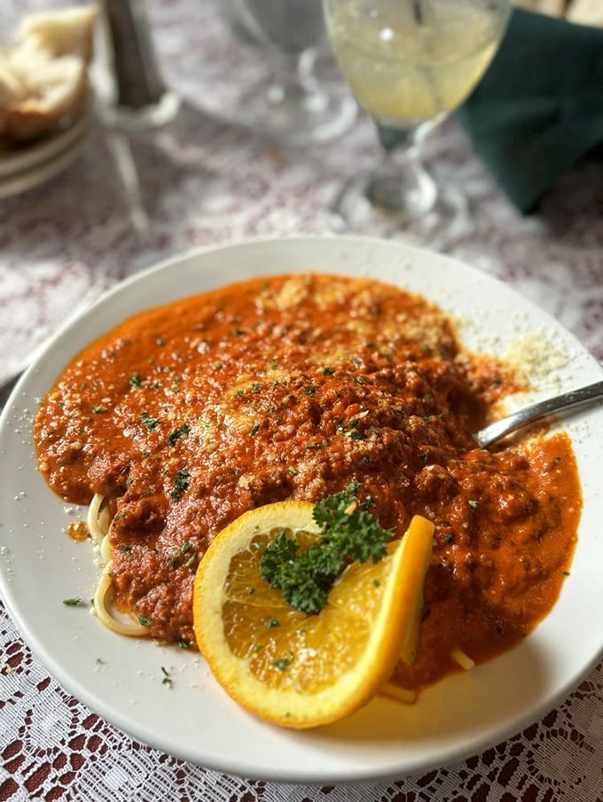 Spaghetti Bolognese that doesn't just satisfy hunger—it solves problems. The orange garnish adds a pop of color like a fashionable Italian accessory.