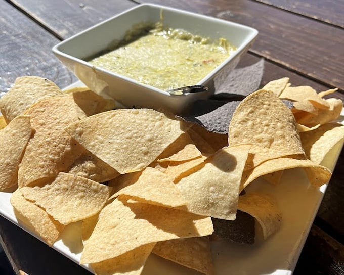 This isn't just spinach artichoke dip—it's a bubbling cauldron of cheese with crispy tortilla chips standing by, ready for their delicious destiny.