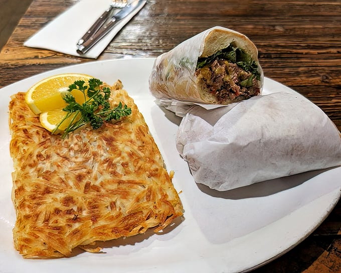 A steak sandwich that demands two hands and no distractions, paired with hash browns that should be in the Crispy Food Hall of Fame.