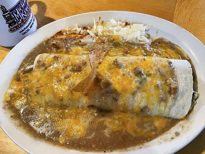 This smothered burrito isn't just food – it's an edible work of art where cheese meets chile in a pool of New Mexican perfection.