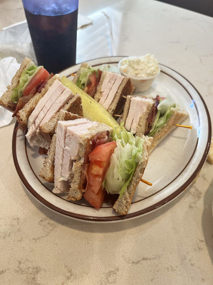 The turkey club sandwich—architecture you can eat. Precisely stacked layers create the skyscraper of sandwiches, held together with toothpick engineering.
