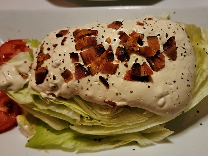 The wedge salad—a steakhouse classic that somehow makes iceberg lettuce exciting. Those bacon bits aren't just toppings; they're little flavor grenades.