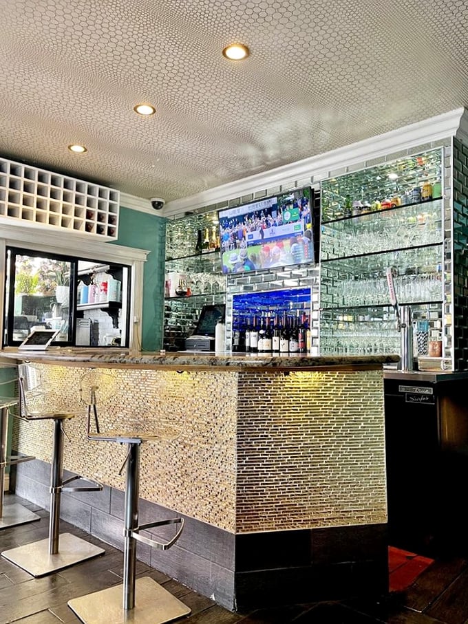 The bar gleams with possibility—mirrored tiles reflecting glasses waiting to be filled with something wonderful. Modern elegance meets casual Venice Beach vibes.
