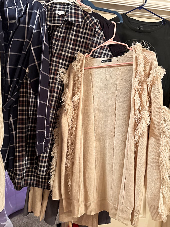 Plaid shirts and fringed cardigans hang in perfect harmony—like a fashion potluck where everyone brought their A-game.