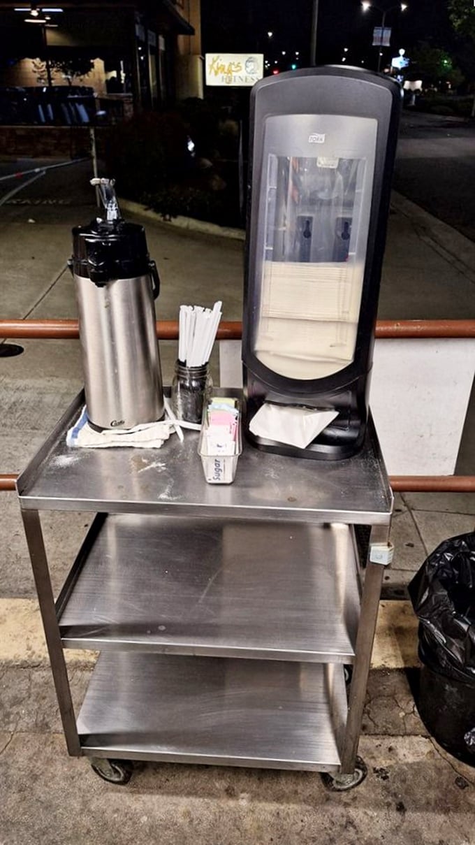 The late-night coffee station—savior of night owls and early birds alike. Where paper cups meet liquid energy beside America's favorite donut stand.