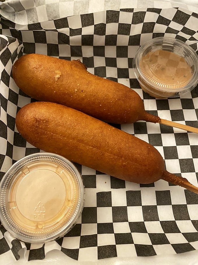 Corn dogs elevated from state fair staple to culinary delight—the perfect golden-brown crust giving way to juicy goodness inside, with dipping sauces standing by for duty.