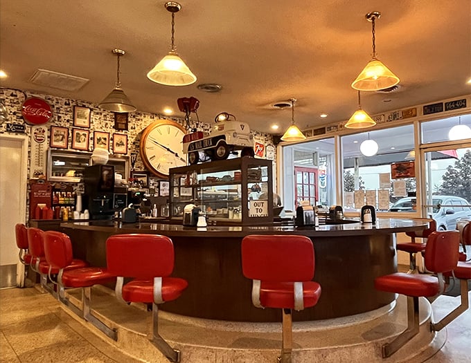 The curved counter with its classic red stools isn't just seating—it's front-row tickets to the greatest show on earth: American diner cuisine.