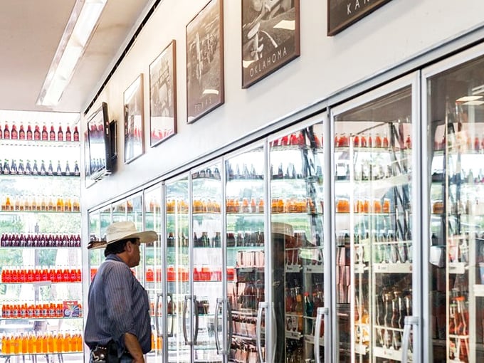 A customer contemplates the wall of liquid possibilities—choosing just one soda from POPS' collection is like being asked to pick a favorite star in the sky.