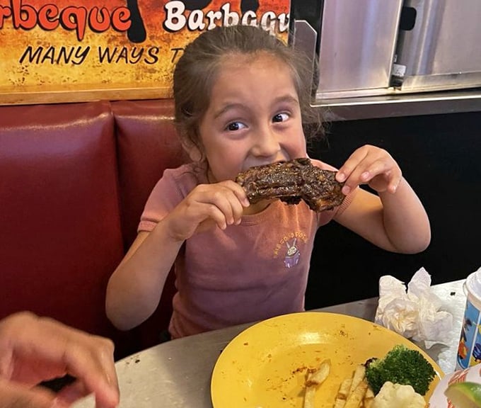 BBQ joy knows no age limit. That face says everything about the transformative power of a perfectly cooked rib—creating memories one messy bite at a time.