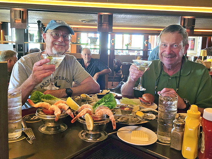 Happy diners toasting life with martinis and seafood towers—proof that the best memories are made between cocktails and dessert.