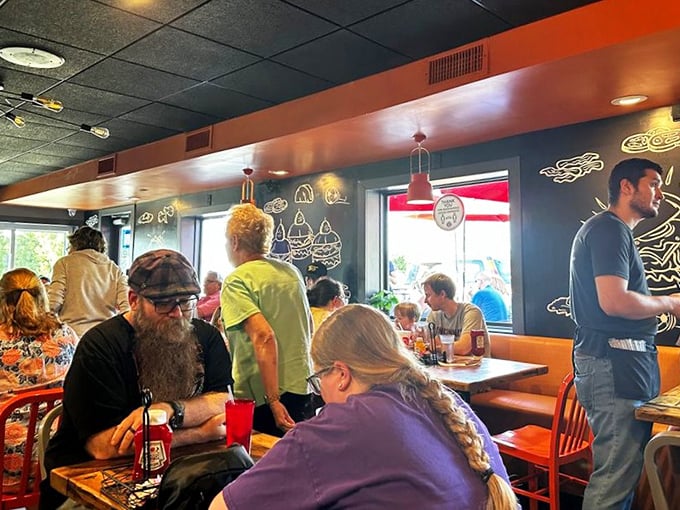 A dining room filled with the universal expression of burger bliss – that quiet moment when conversation pauses for pure enjoyment.