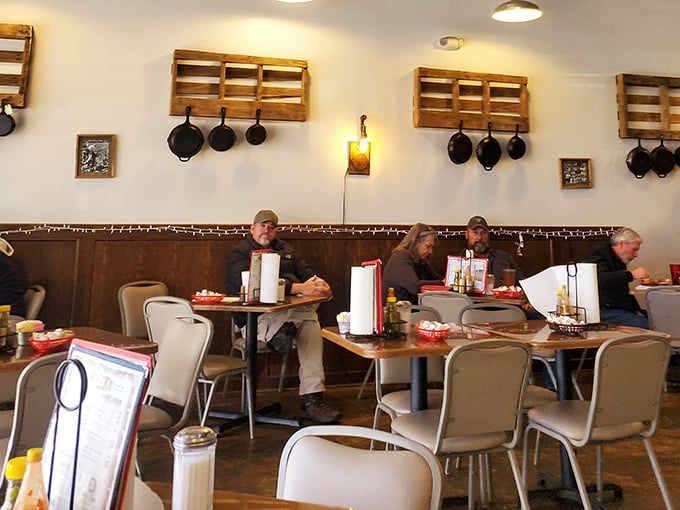 The morning crowd settles in beneath cast iron decor, each table hosting its own mini-community. Breakfast here is both sustenance and social event.