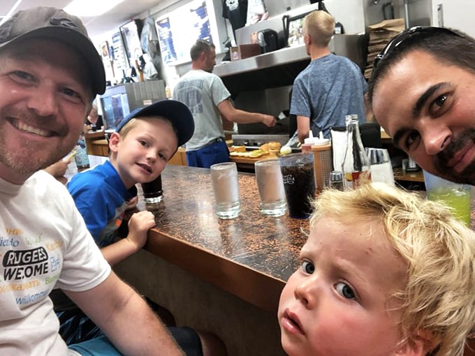Three generations sharing counter space and burger bliss. This is how food traditions survive—one family meal at a time.