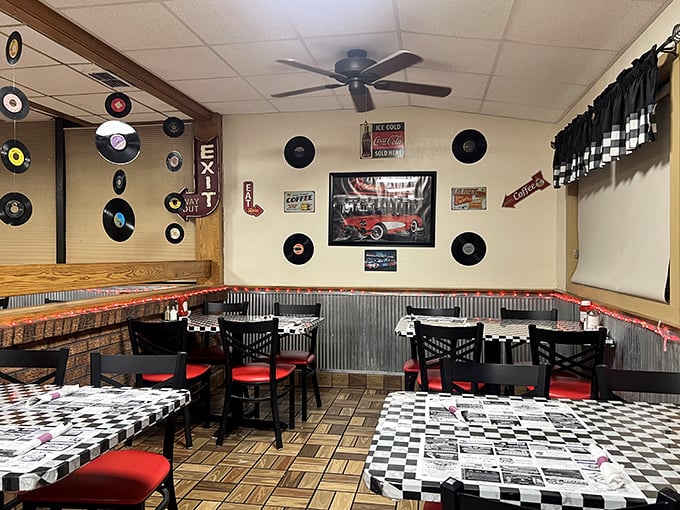 Records on the wall, checkered tablecloths, and red chairs—this isn't just decoration, it's a time machine set to "American Classic."