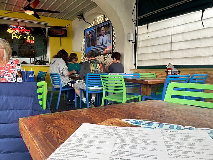 Colorful chairs and rustic wooden tables create Woody's signature "come as you are" vibe—flip-flops and appetites equally welcome.