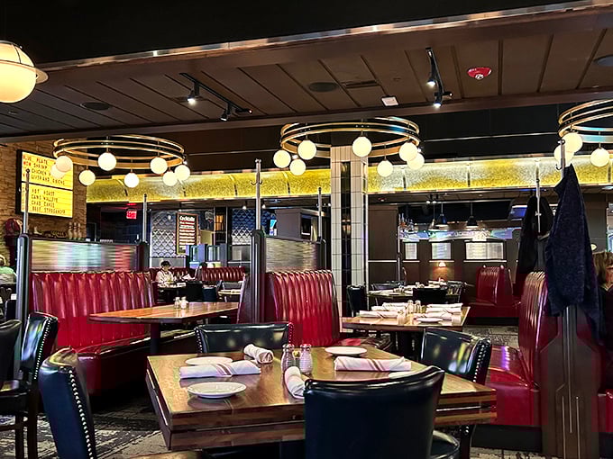 Circular light fixtures hover like friendly UFOs above cherry-red booths, creating an atmosphere that's both nostalgic and thoroughly modern.