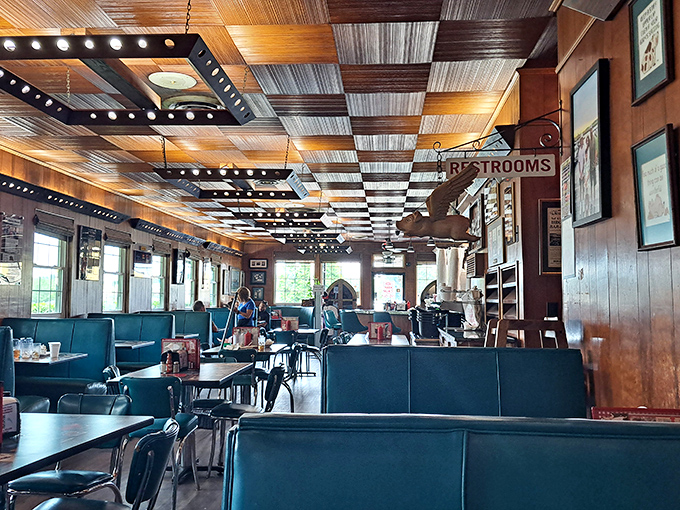 The dining room hums with conversation and satisfaction, where blue vinyl booths have witnessed decades of first dates and family celebrations.