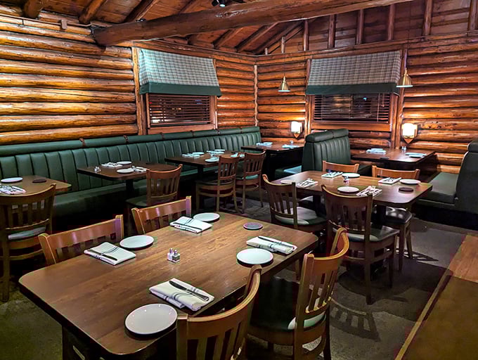 Green booth seating and wooden tables create intimate dining nooks within the log walls, like discovering a secret mountain lodge minutes from Cleveland.