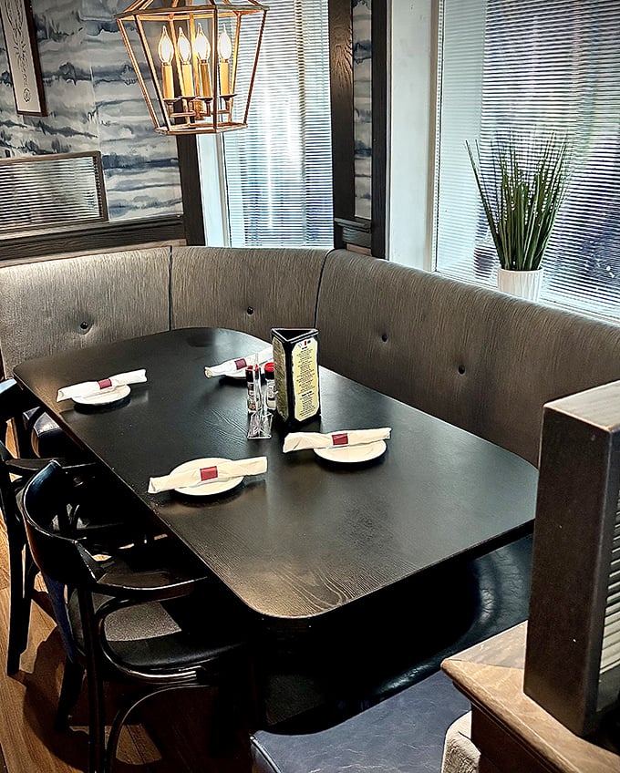 This curved booth isn't just seating—it's a front-row ticket to the seafood show, complete with elegant lighting and ocean-inspired wallpaper setting the maritime mood.