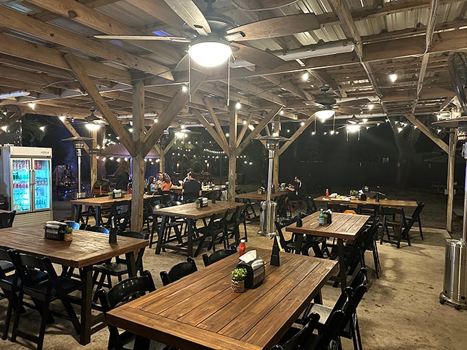 As night falls, the string lights transform this wooden pavilion into a magical dining oasis where memories are made between bites.