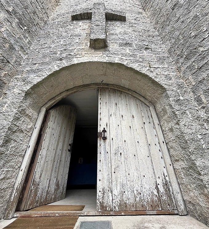 These weathered wooden doors could tell stories. Cross-shaped cutouts in the stone above hint at the castle's spiritual purpose.