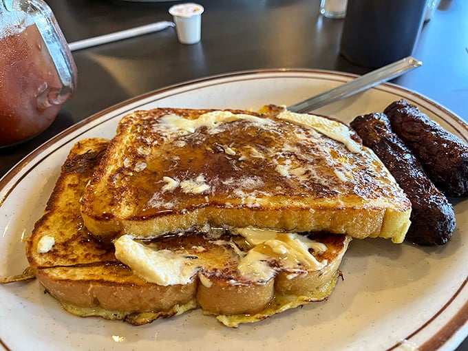 French toast so perfectly golden-brown it belongs in a museum, paired with sausage links that make a compelling argument against plant-based alternatives.