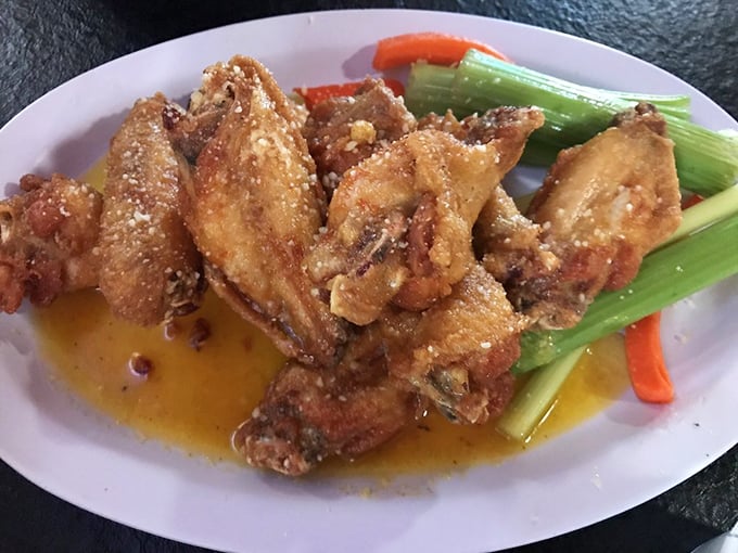 These wings aren't just fried, they're transformed – glistening with sauce and surrounded by cooling celery like tasty little life rafts.