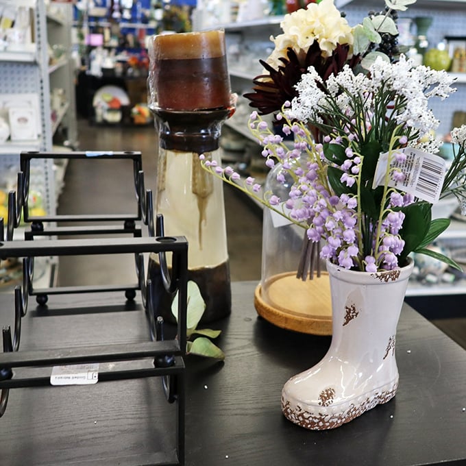 A porcelain boot blooms with artificial flowers beside mysterious glass-domed curiosities—the home décor section is where whimsy meets practicality.