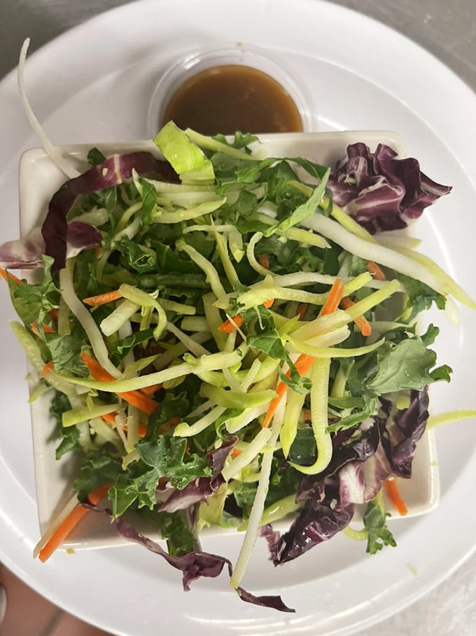 A fresh garden salad that offers a crisp, verdant respite between bouts of seafood indulgence—balance in all things, even feasting.