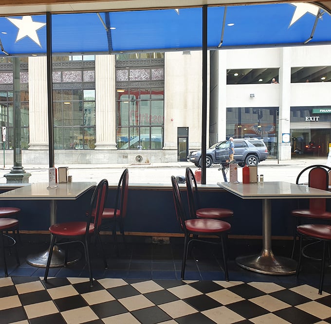 Window seats offer prime people-watching while you navigate your delicious, messy masterpiece with strategic precision.
