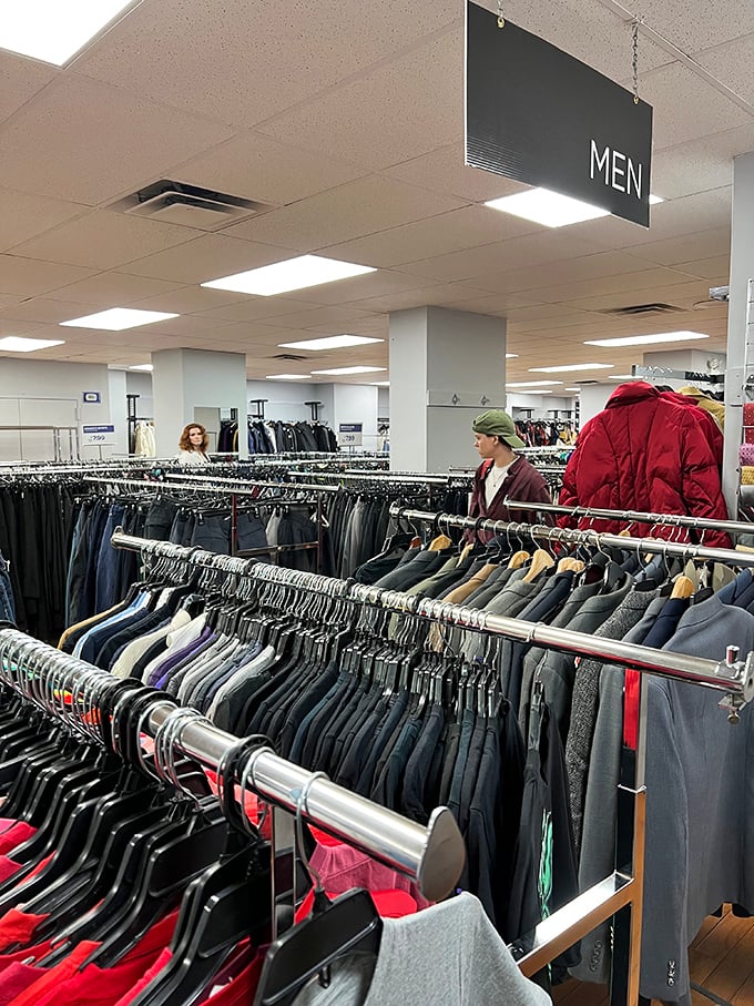 The men's section: where yesterday's Wall Street wardrobes become tomorrow's creative agency outfits. Transformation hanging on metal racks.