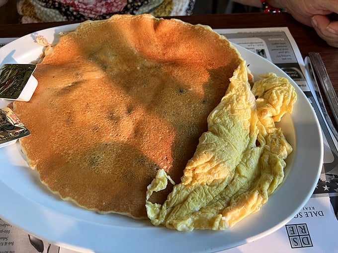 This pancake isn't just big – it's Florida-retirement-condo big, taking up real estate on the plate with eggs nestled alongside like good neighbors.
