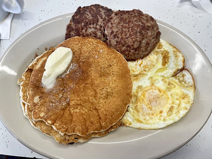A pancake, eggs, and sausage patty—the breakfast equivalent of a greatest hits album where every track deserves to be there.