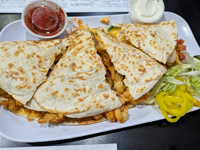 This quesadilla isn't messing around – stuffed to capacity and perfectly grilled. The accompanying condiments are standing by for flavor enhancement duty.